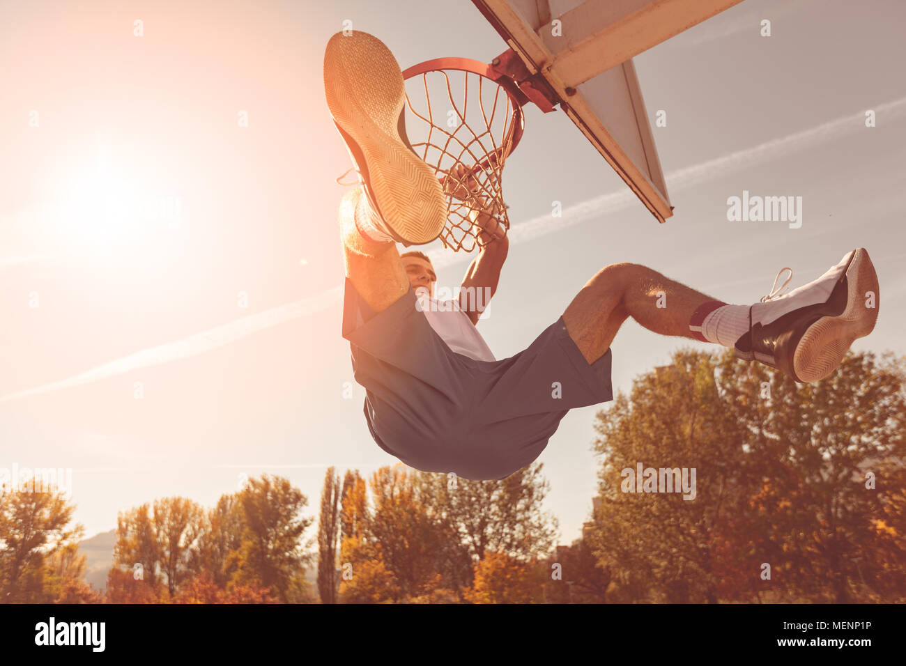 Street basketball player performing power slum dunk Stock Photo - Alamy