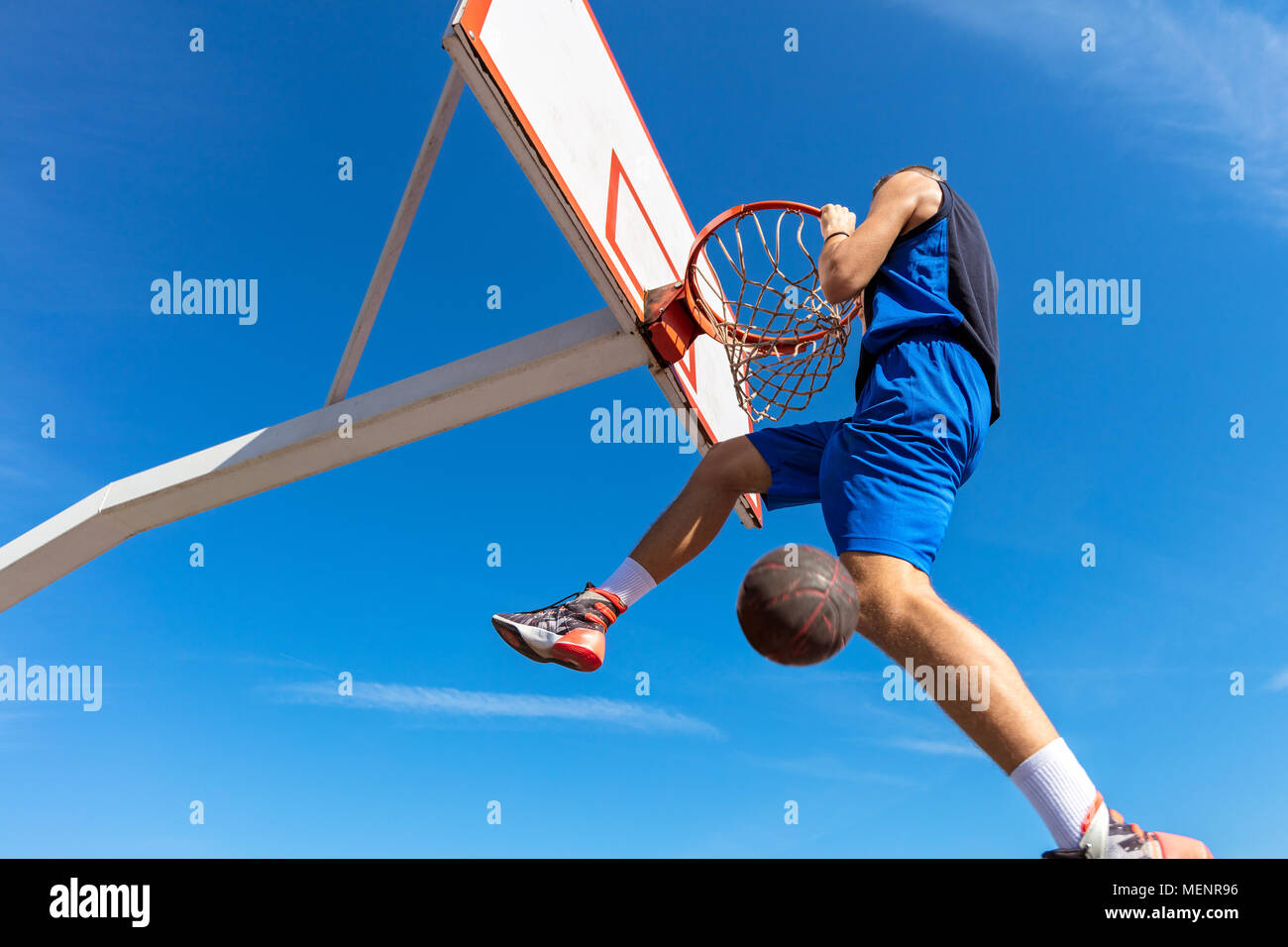 Slam Dunk. Side view of young basketball player making slam dunk Stock ...