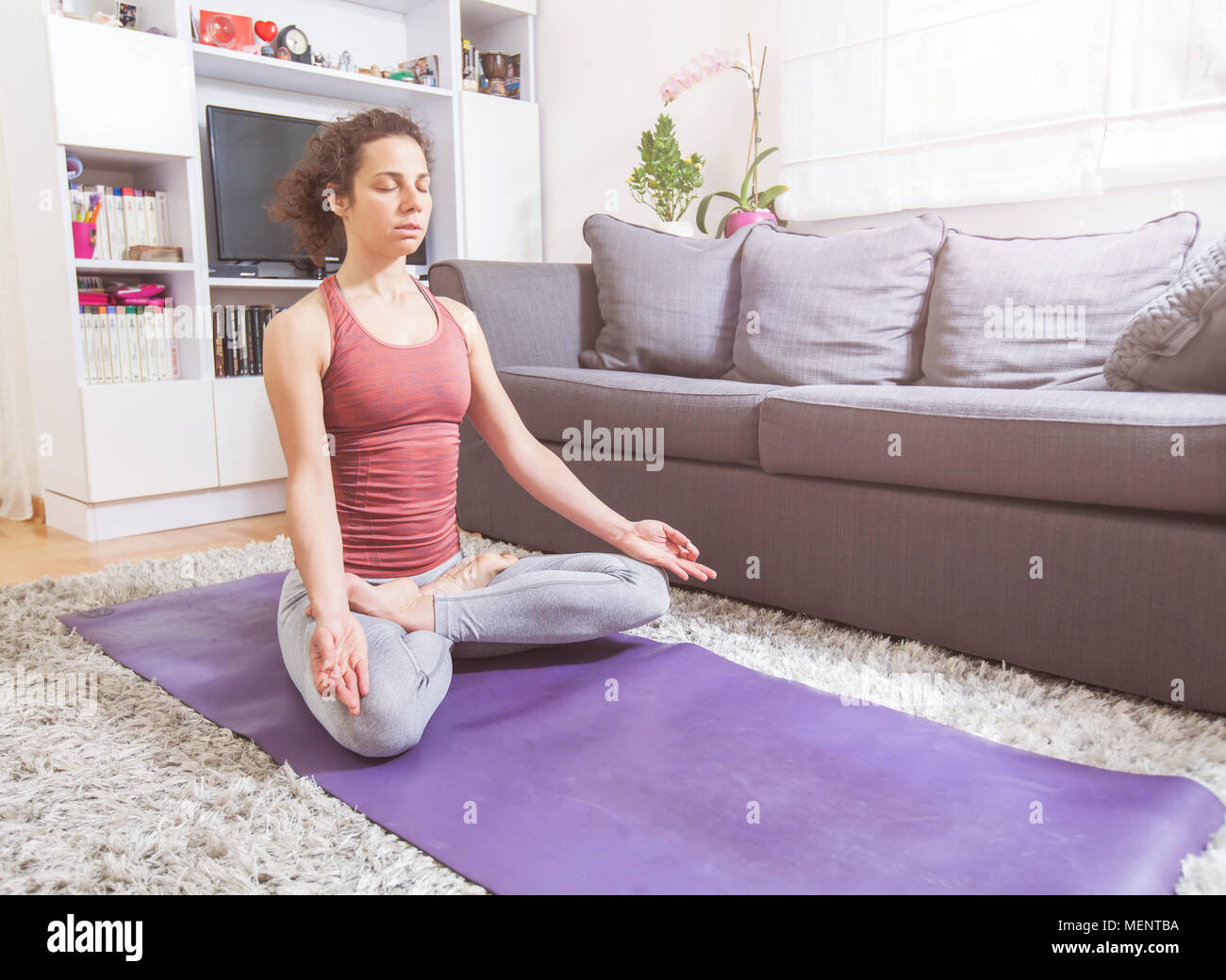 Young Woman Meditating, Practicing Yoga, half lotus pose, ardha ...