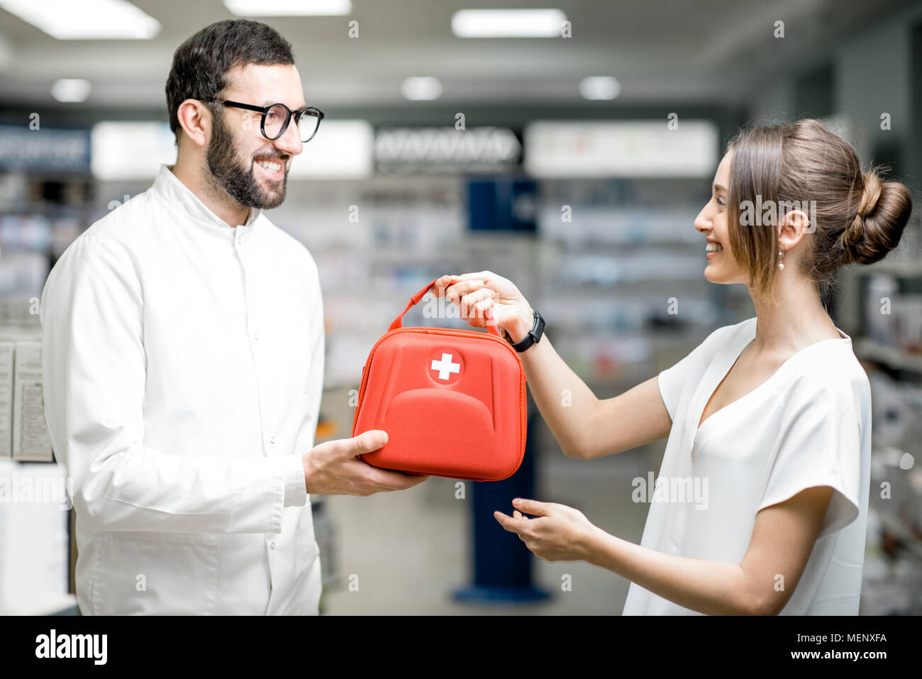 Pharmacist with client and first aid kit in the pharmacy Stock Photo ...