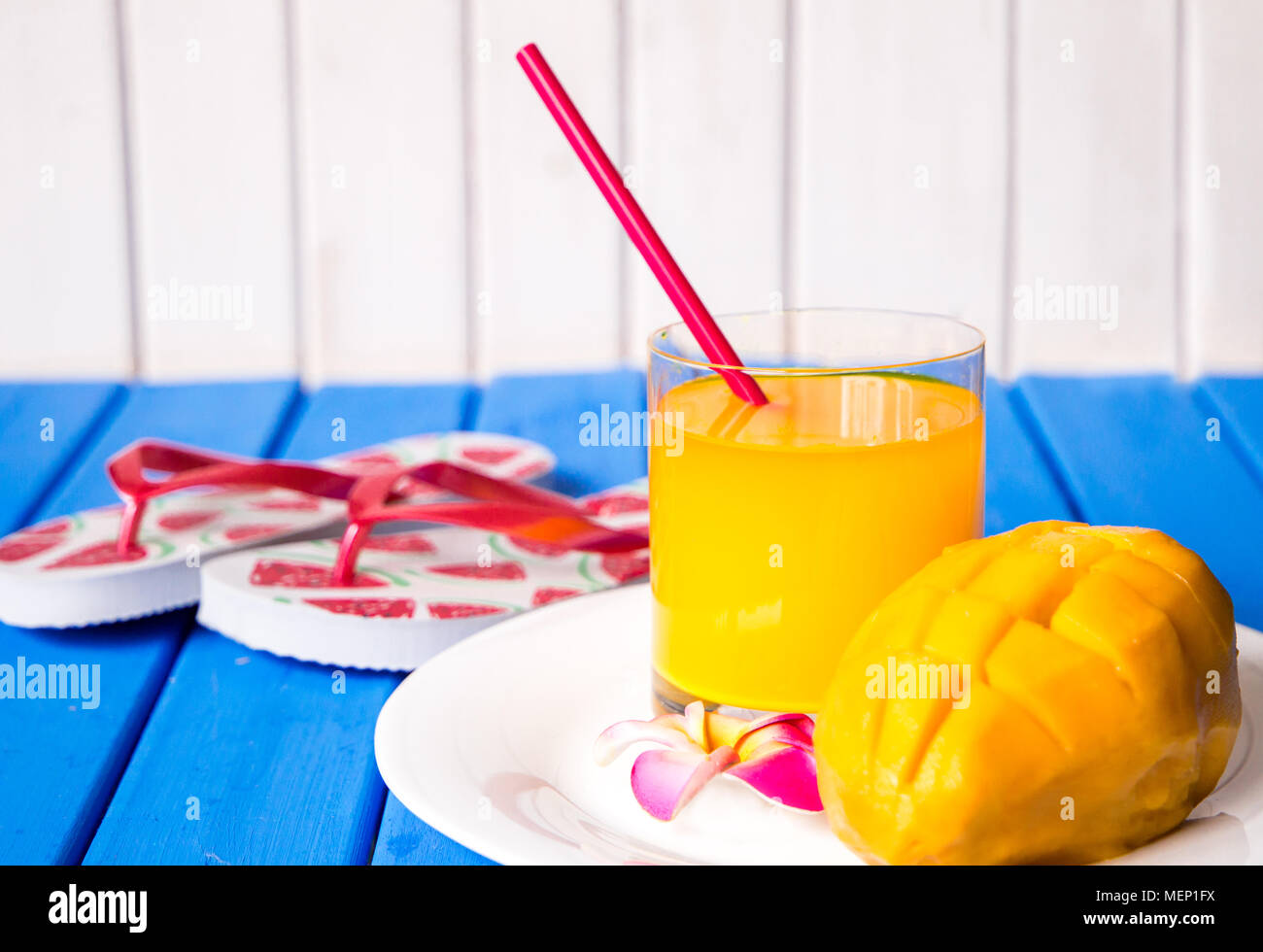 Mango smoothie in a glass glass and mango on a blue background. Mango ...