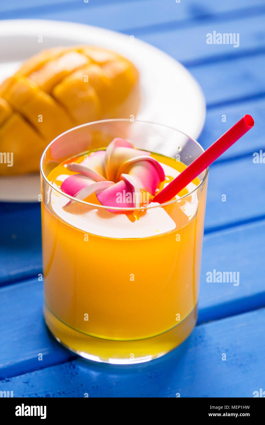 Mango smoothie in a glass glass and mango on a blue background. Mango ...