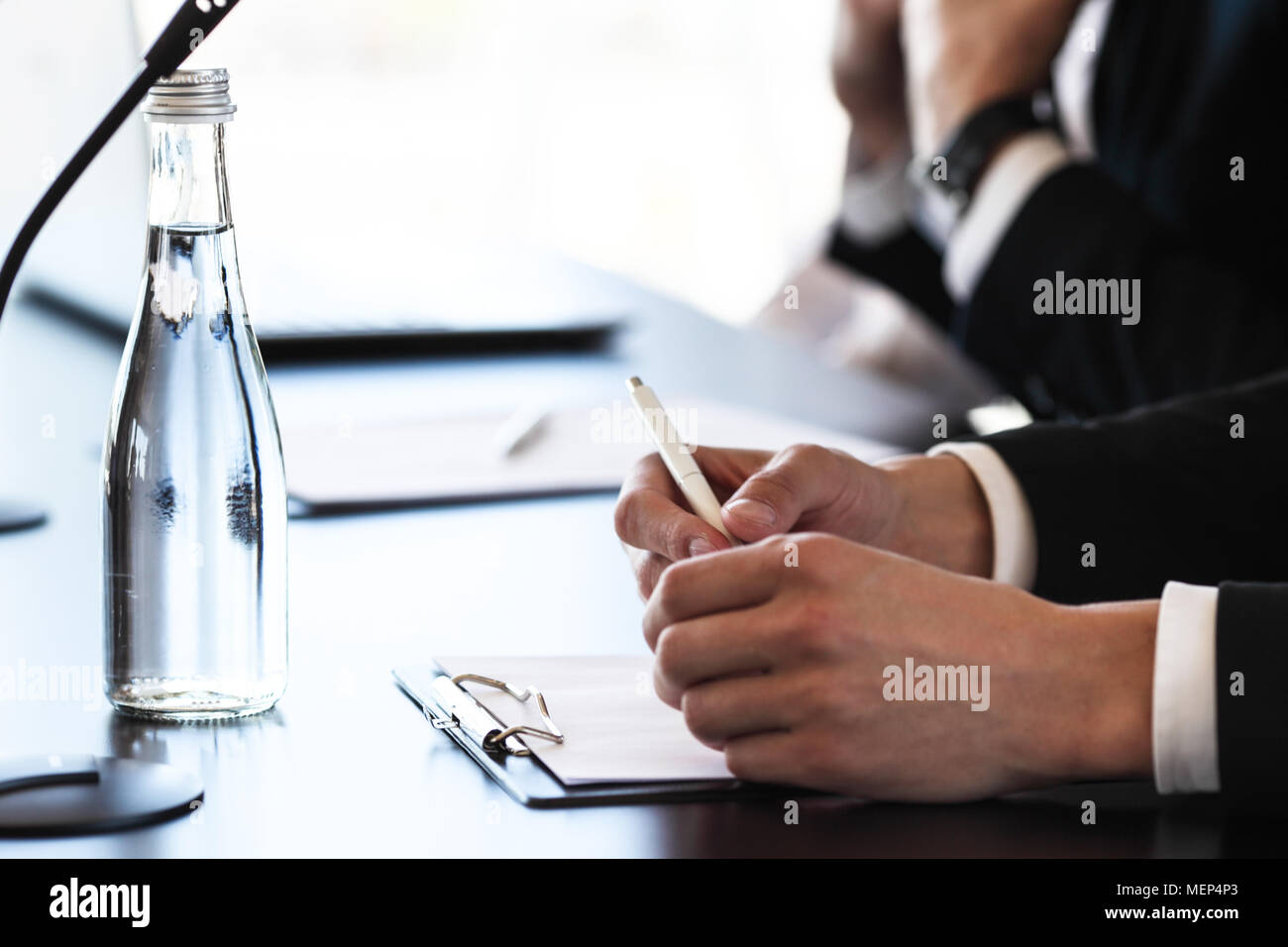 Group of speakers at business meeting at the table with microphones ...