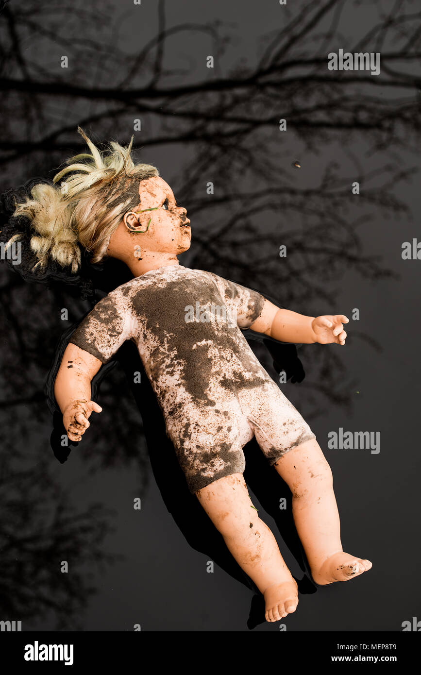 Overhead view of dirty plastic doll lying in a shallow puddle Stock ...