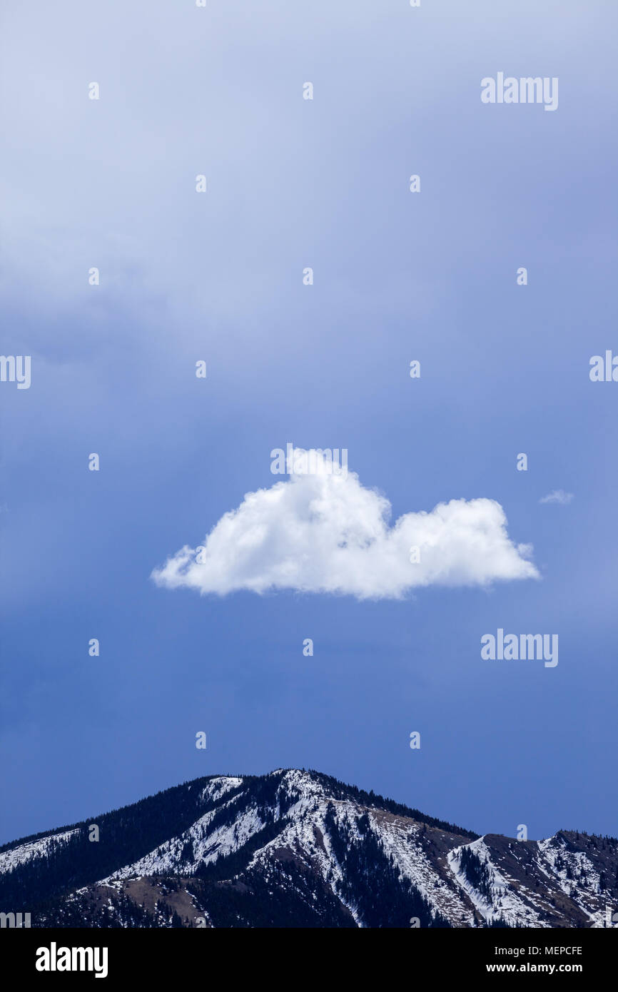 A single white cloud above a mountain peak Stock Photo - Alamy