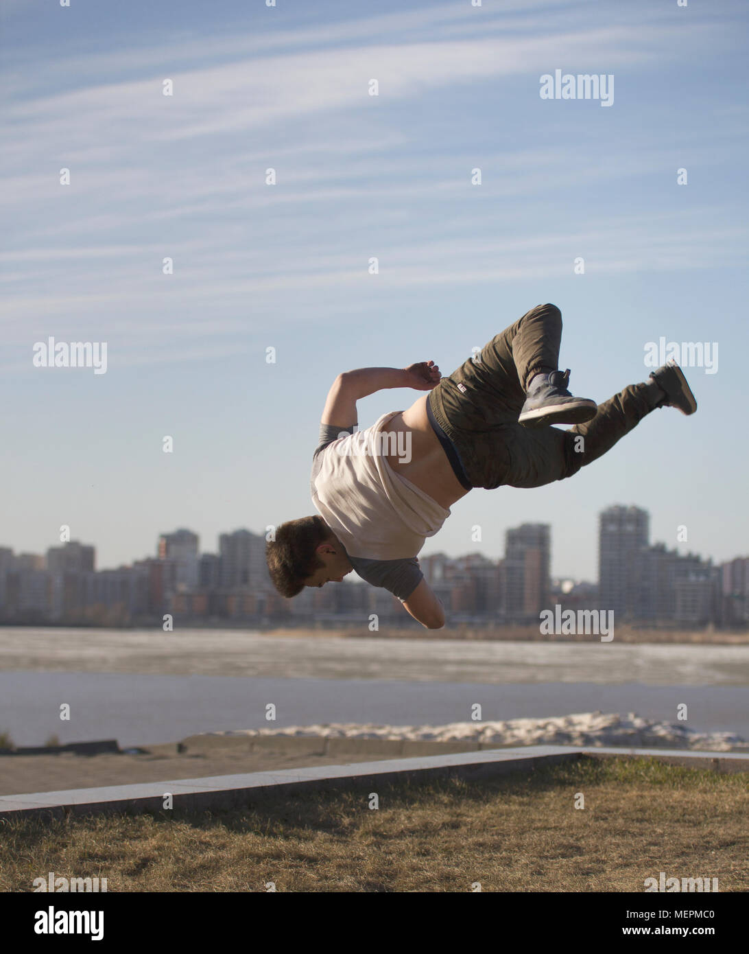 Young man parkour sportsman performs tricks in front of skyline Stock ...