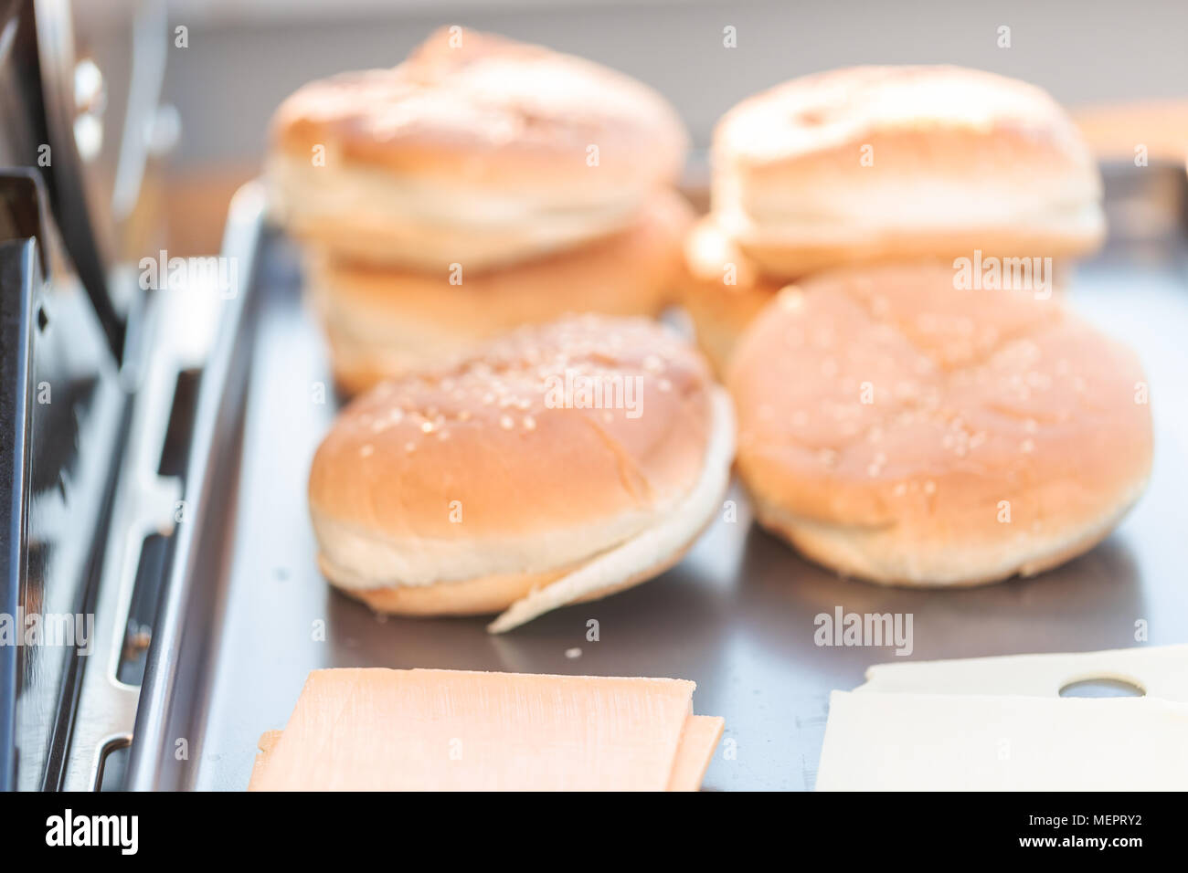 Step by step. Hamburger buns on the tray next to outdoor gas grill ...