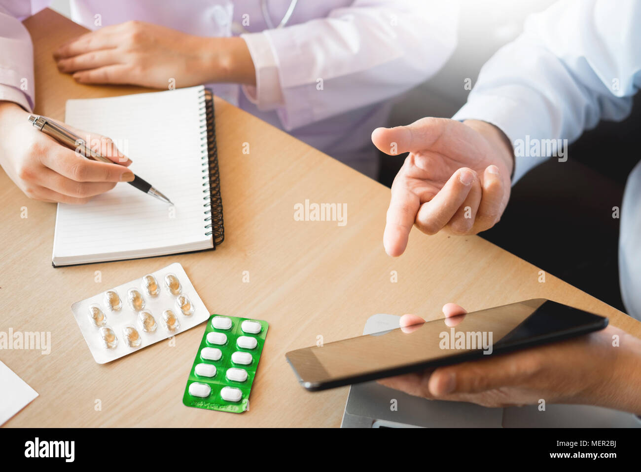 doctor hand holding tablet of drug and explain to patient in hospital ...