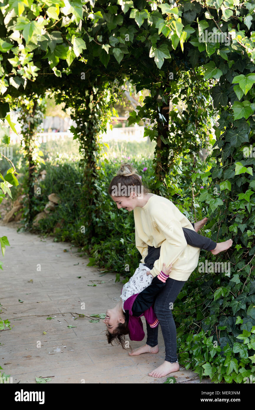 Two sisters playing in a garden. Vertical shot with natural light Stock ...