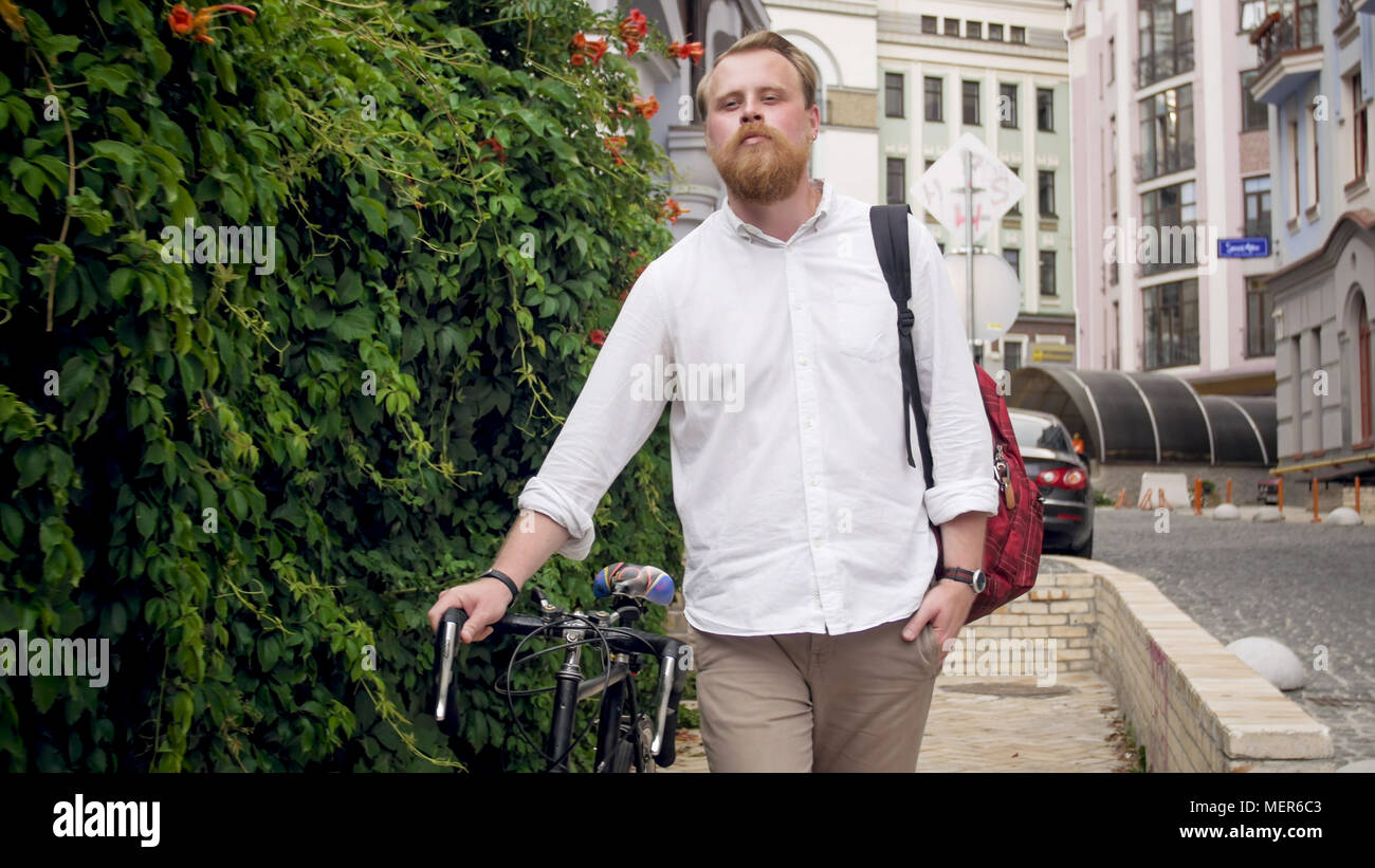 Portrait of stylish man walking to work with bicycle Stock Photo - Alamy