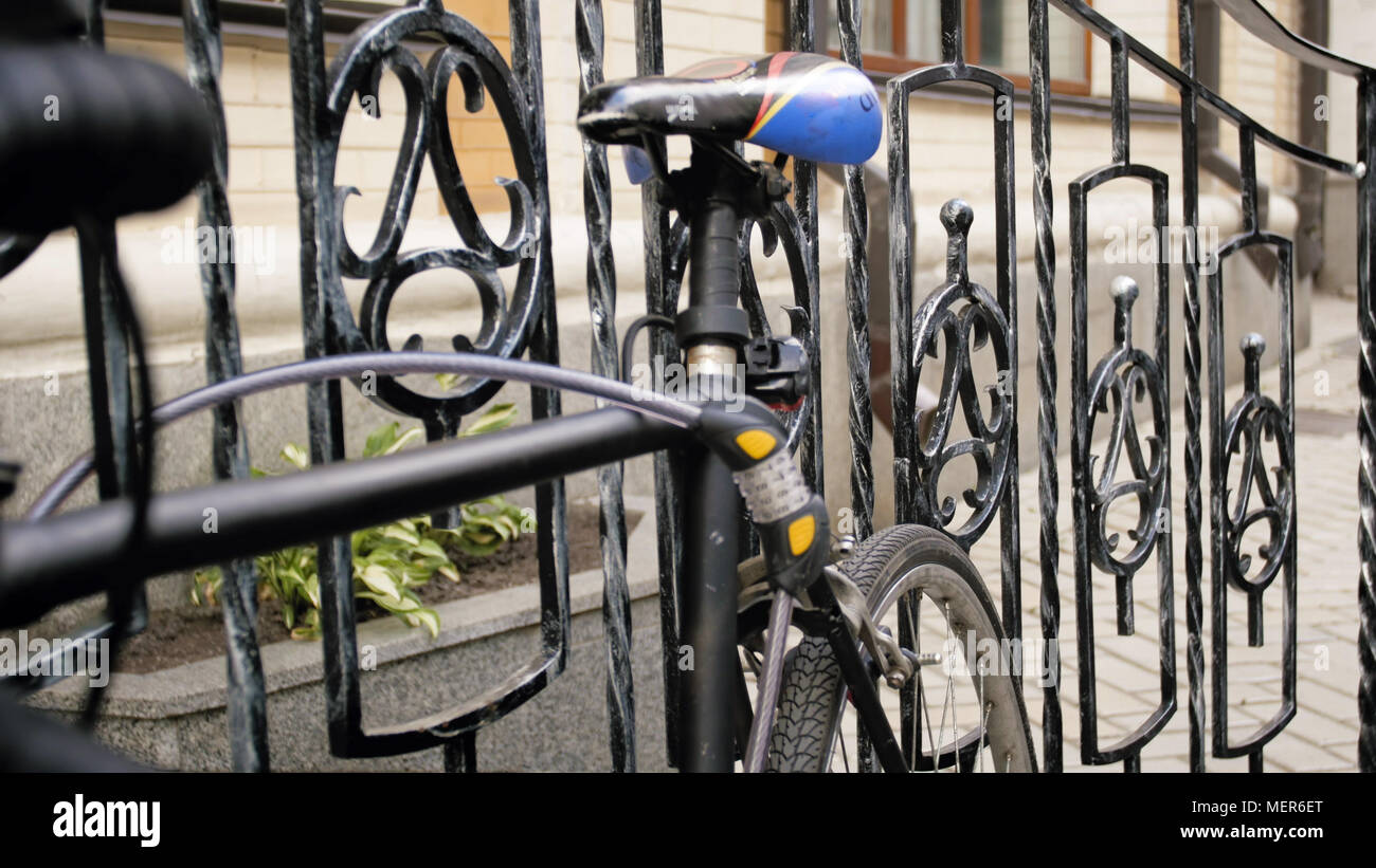 Closeup photo of vintage bicycle locked to metal fence on street Stock ...