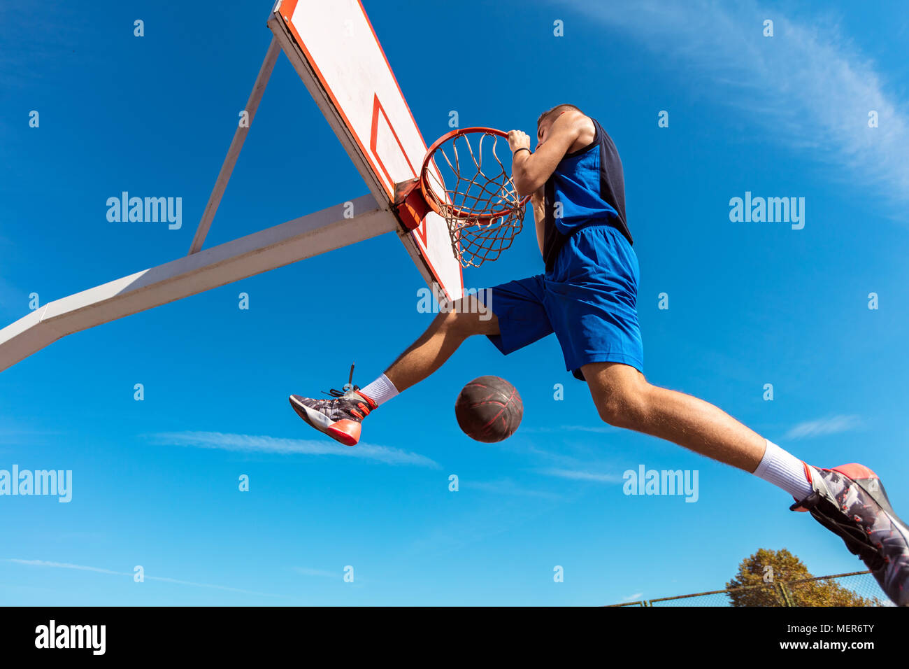 Slam Dunk. Side view of young basketball player making slam dunk Stock ...