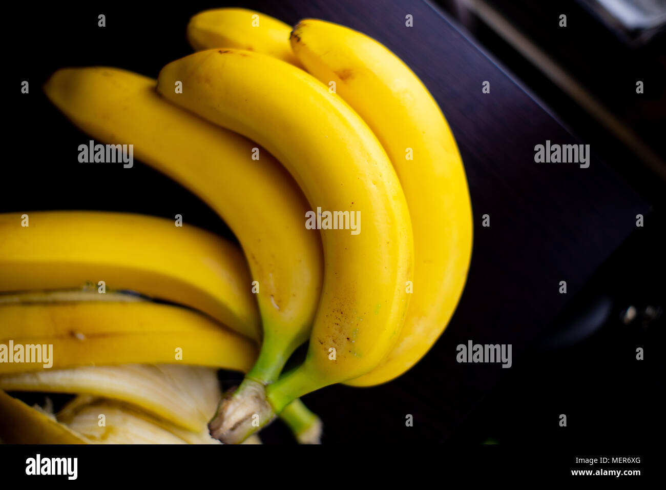 Bunch of fresh yellow bananas along with eaten bananas' skin Stock ...