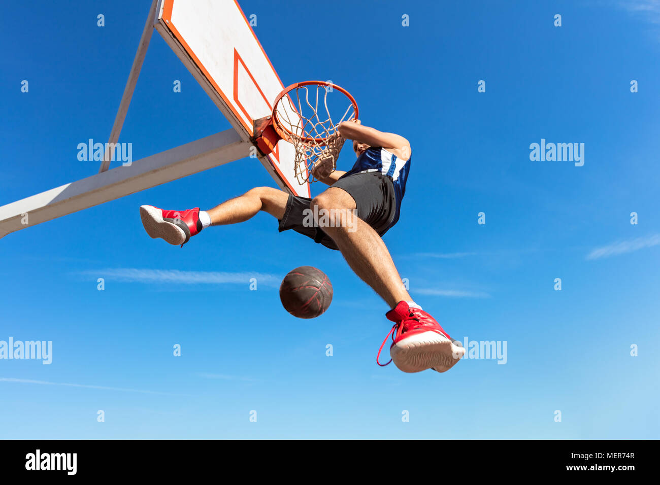 Slam Dunk. Side view of young basketball player making slam dunk Stock ...