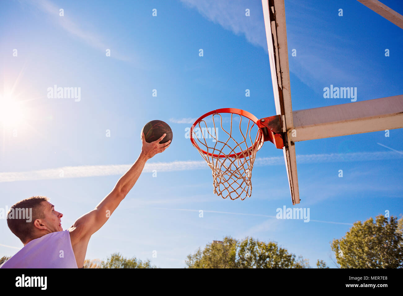 Slam Dunk. Side view of young basketball player making slam dunk Stock ...