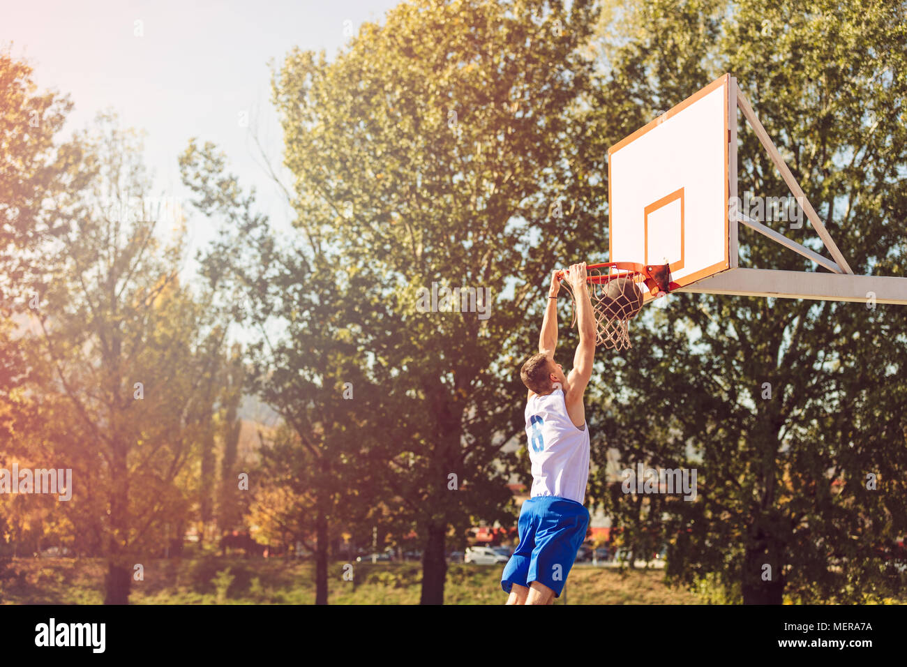 Street basketball player performing power slum dunk Stock Photo - Alamy