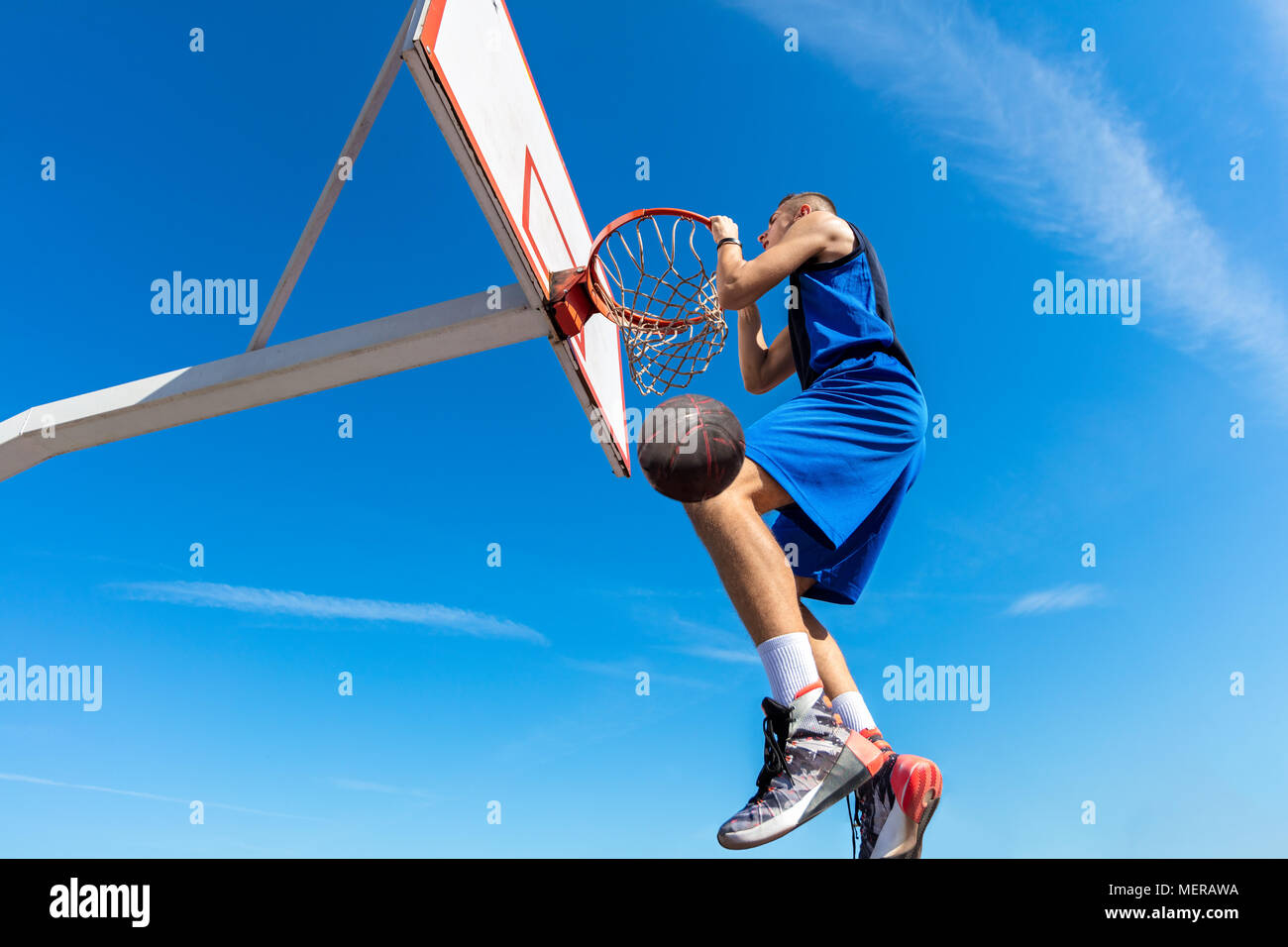 Slam Dunk. Side view of young basketball player making slam dunk Stock ...