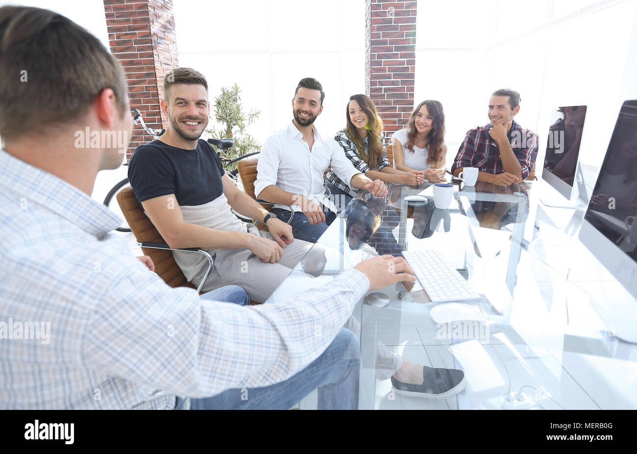 business team sitting at a modern Desk Stock Photo - Alamy