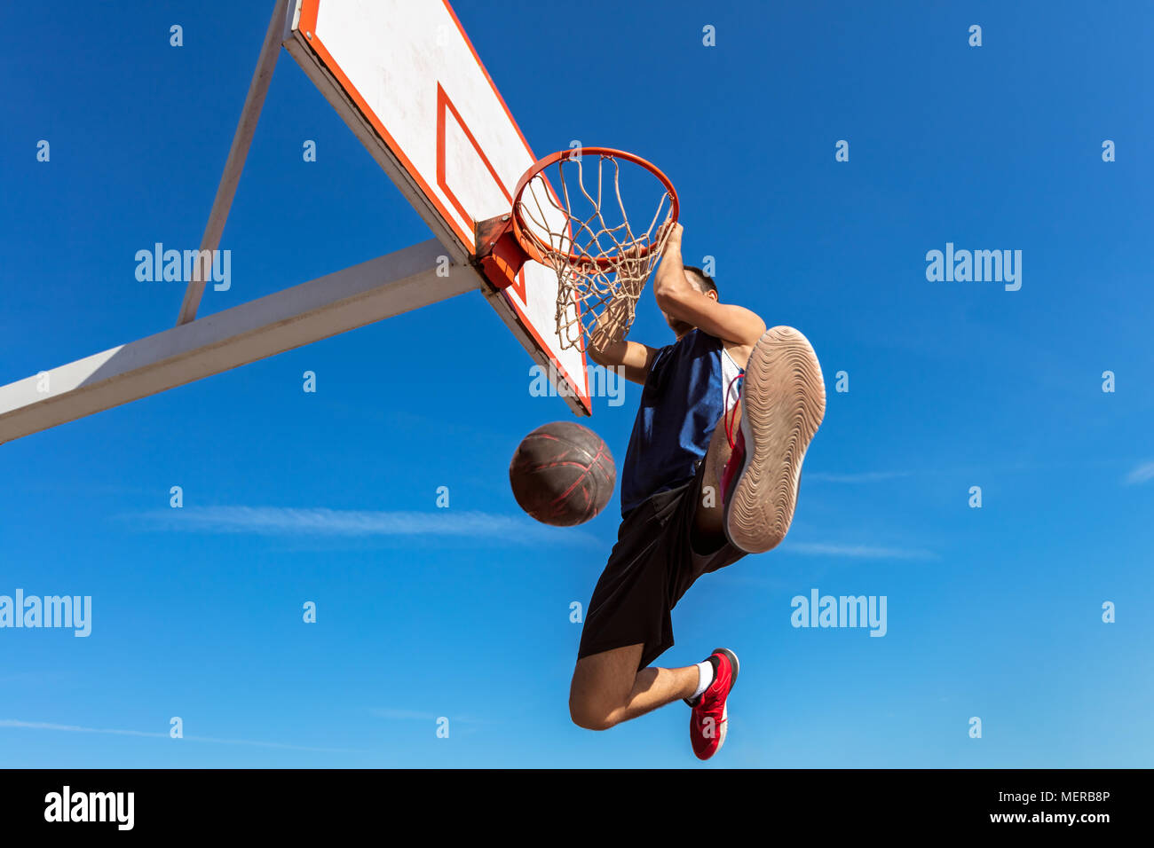 Slam Dunk. Side view of young basketball player making slam dunk Stock ...