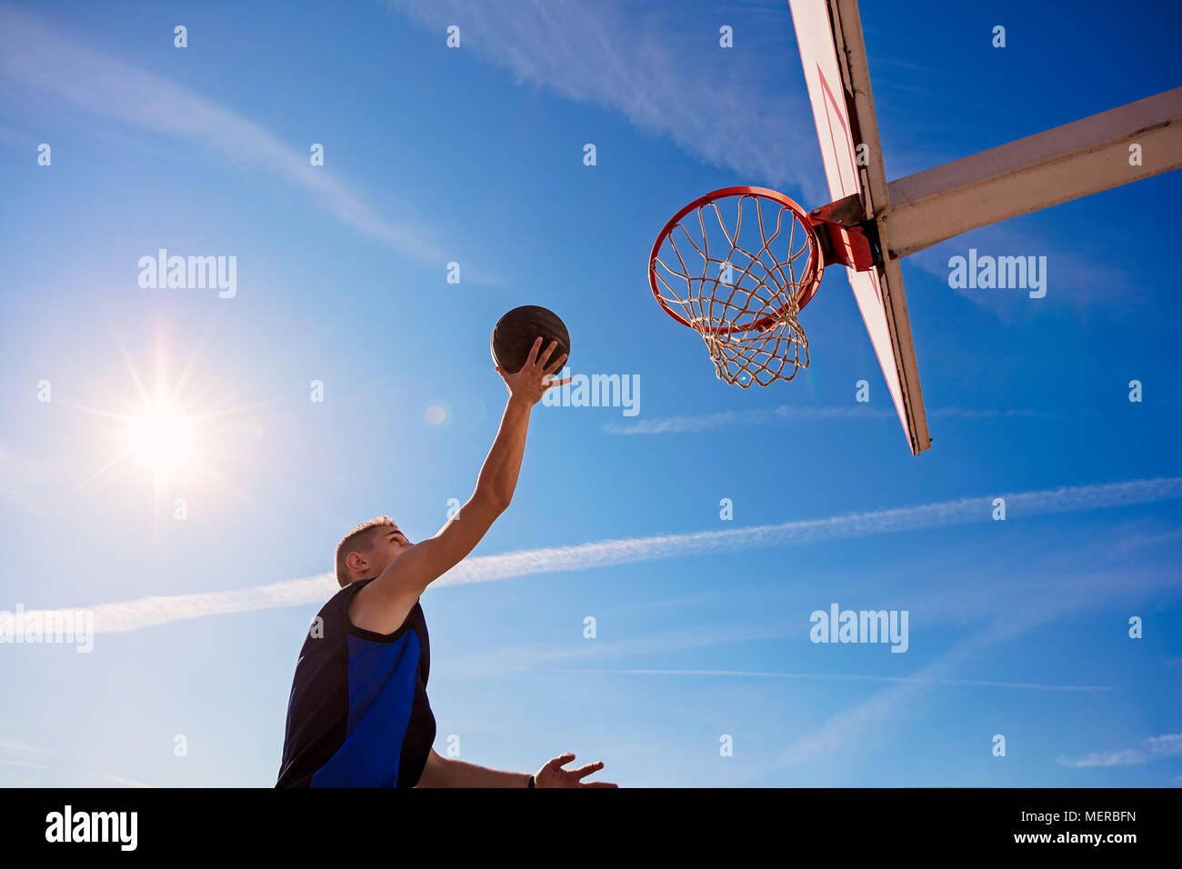 Slam Dunk. Side view of young basketball player making slam dunk Stock ...
