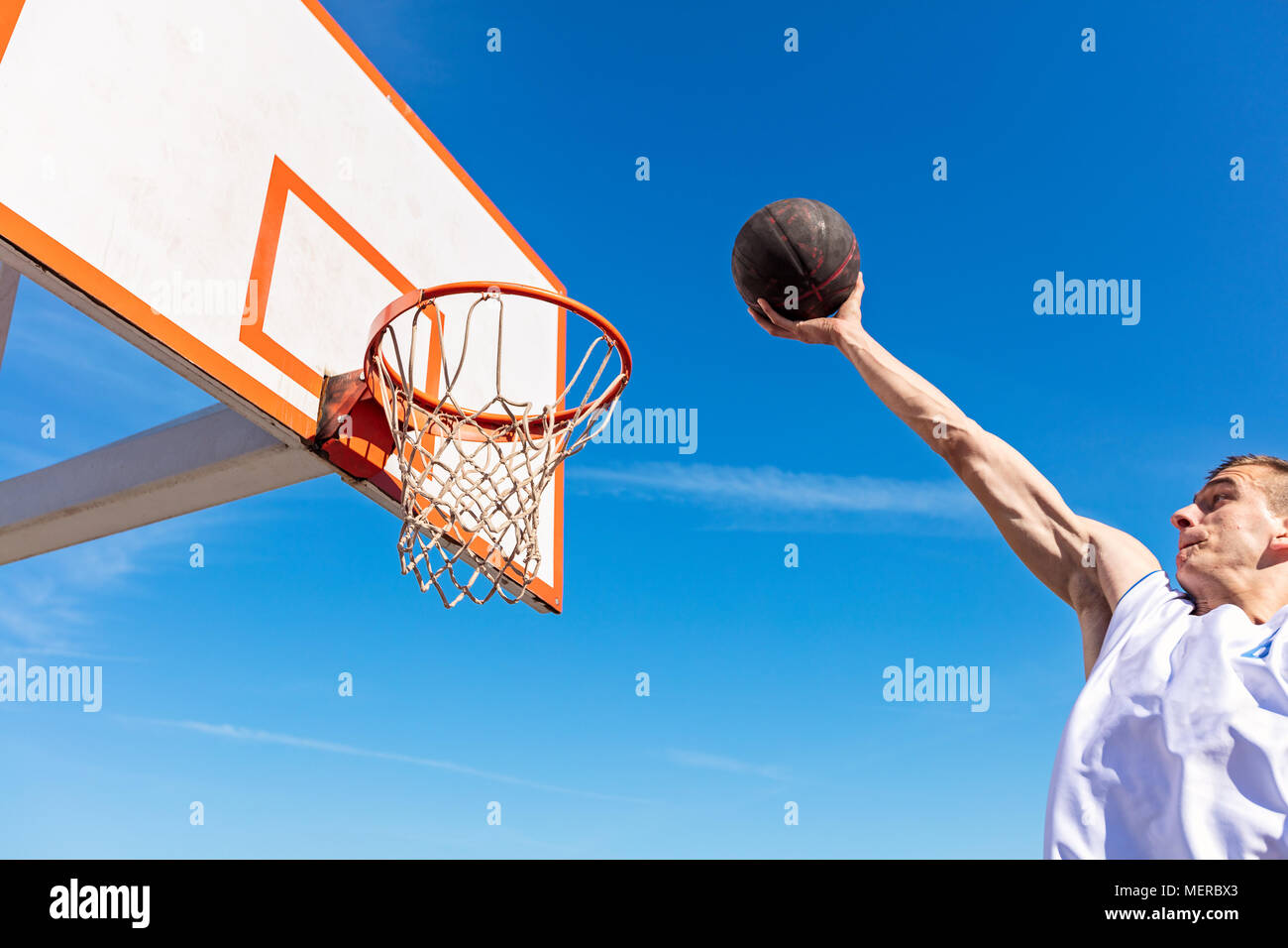 Slam Dunk. Side view of young basketball player making slam dunk Stock ...