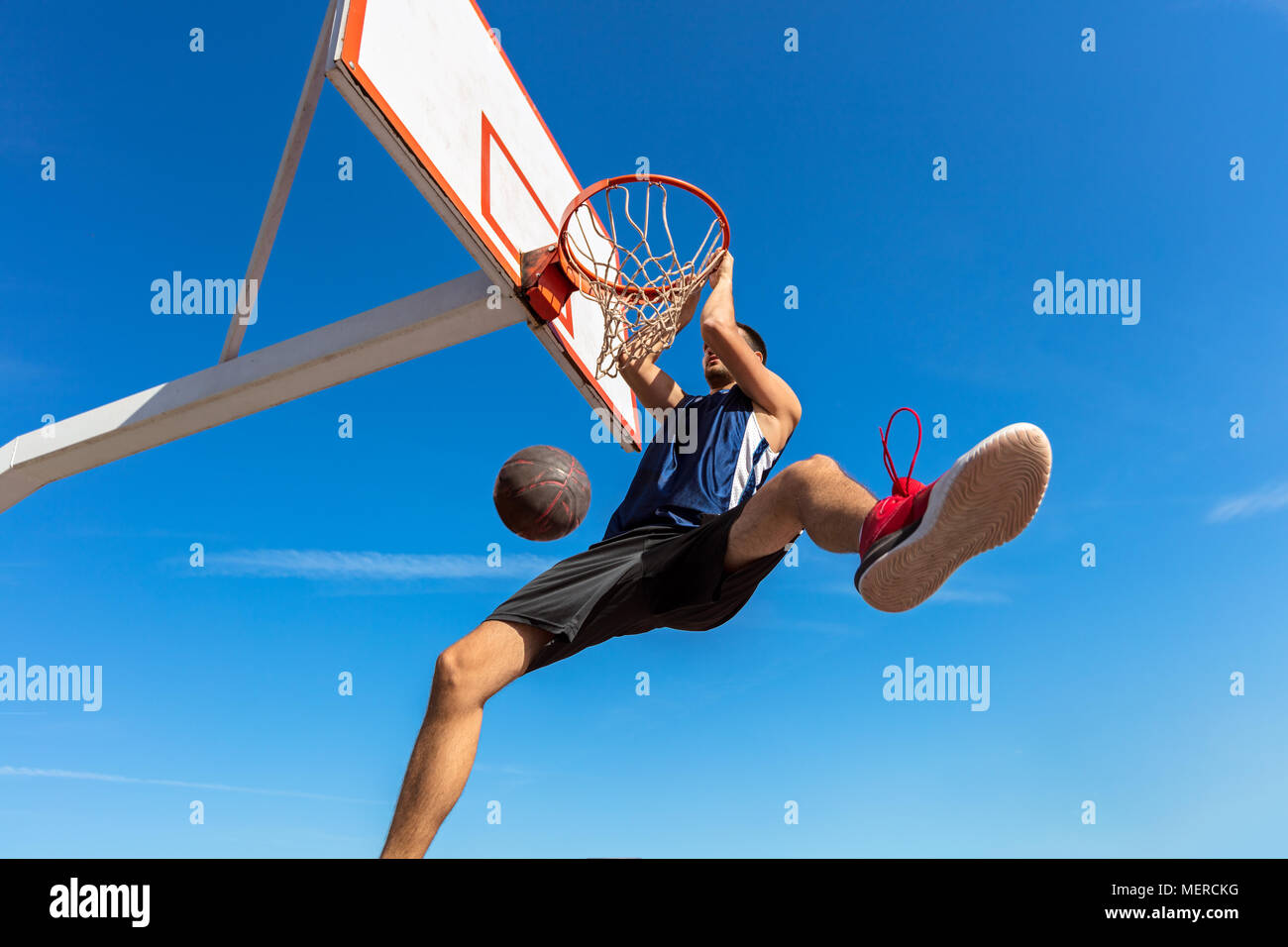 Slam Dunk. Side view of young basketball player making slam dunk Stock ...