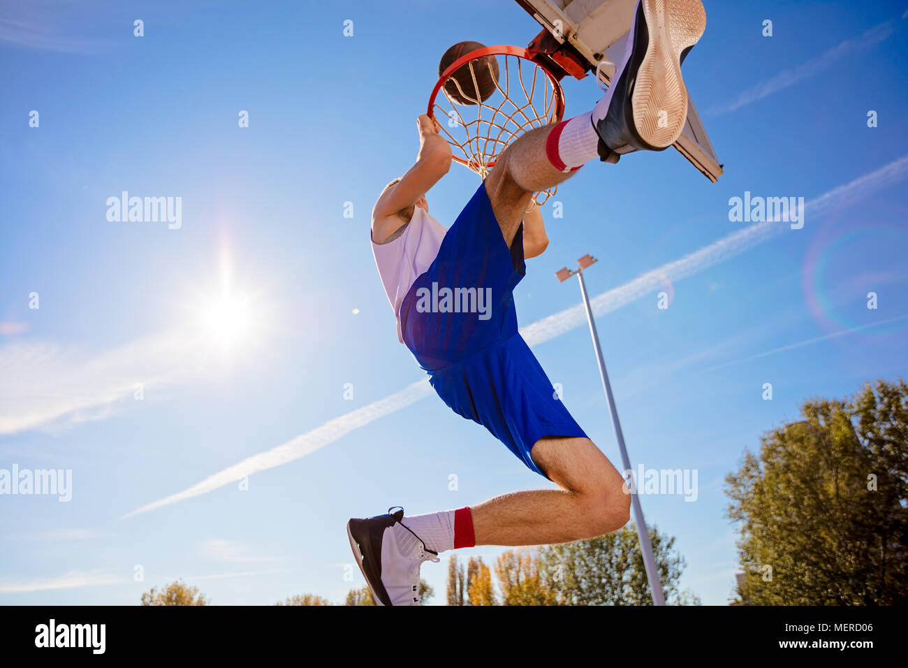 Slam Dunk. Side view of young basketball player making slam dunk Stock ...