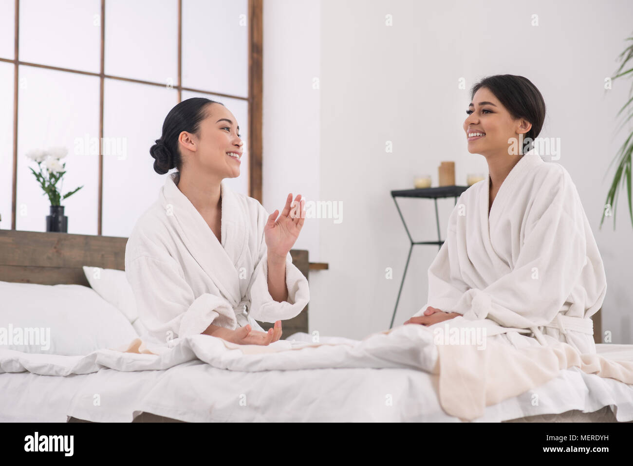 Positive delighted friends talking Stock Photo - Alamy