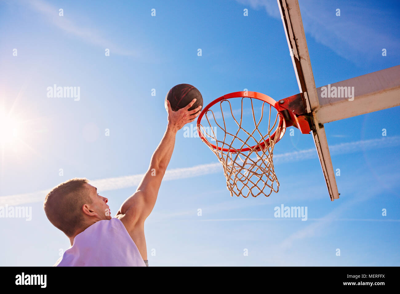 Slam Dunk. Side view of young basketball player making slam dunk Stock ...