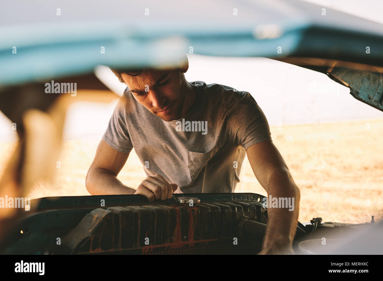 Man repairing his car opening the hood. Man fixing his car on highway ...