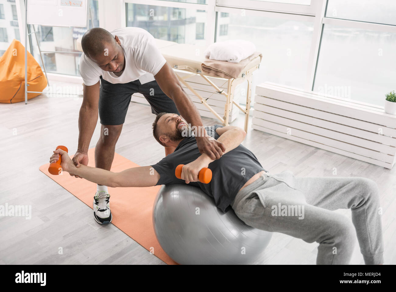 Serious skilled coach working with a patient Stock Photo - Alamy