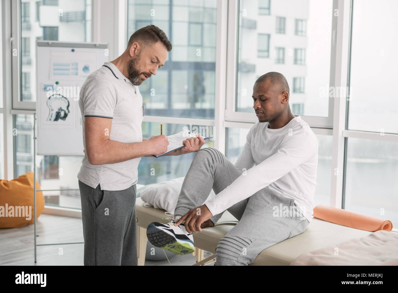 Sad cheerless man pointing at his foot Stock Photo - Alamy