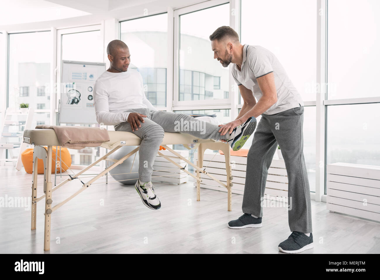 Nice young man bending his leg Stock Photo - Alamy