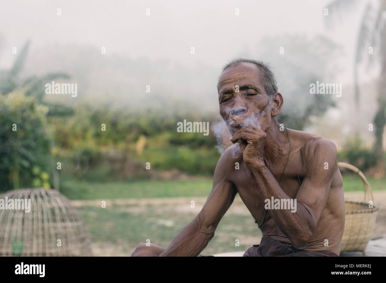 Asian men smoking cigarettes in rural of Thailand Stock Photo - Alamy