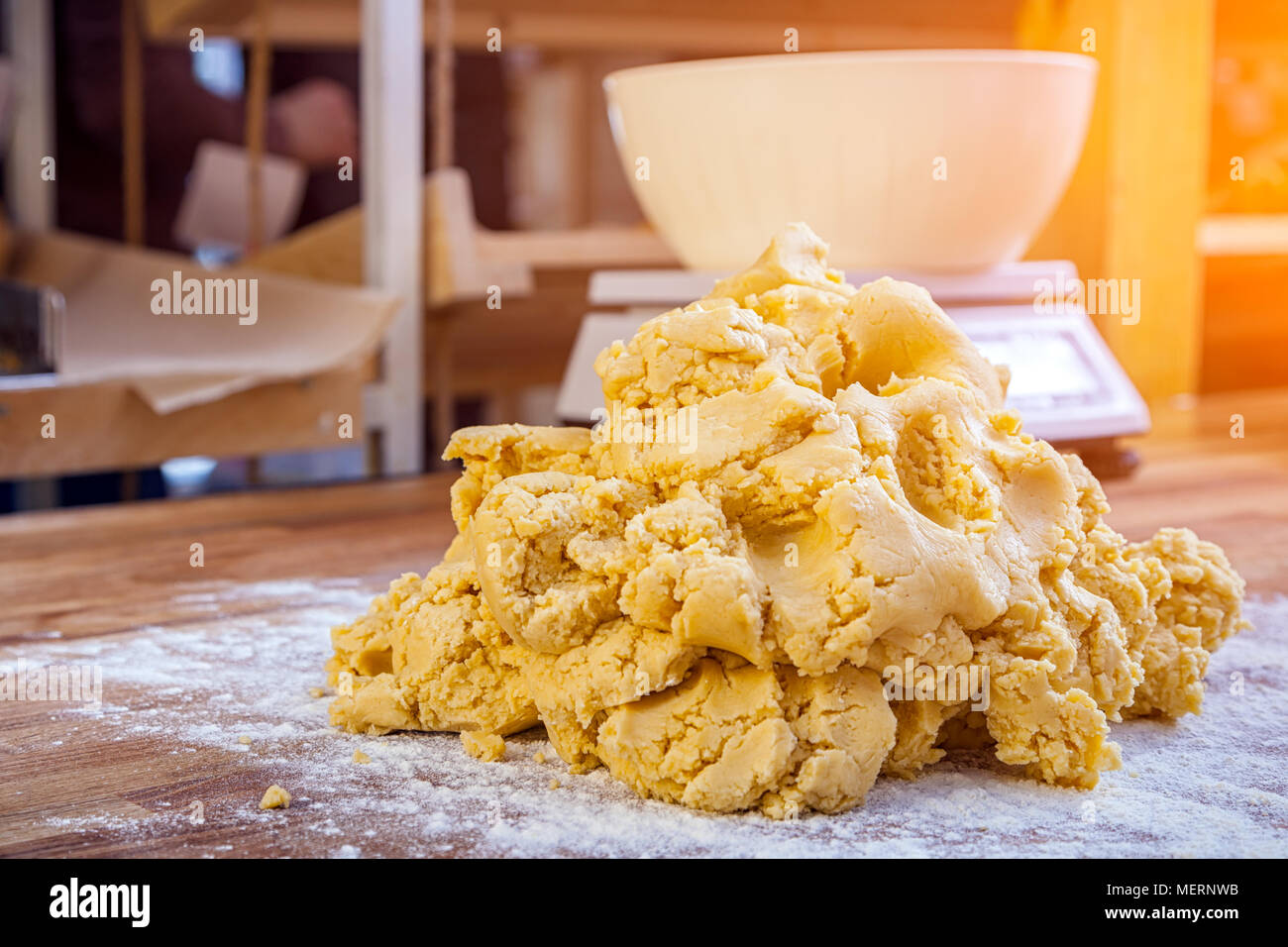Close-up of fresh dough for cooking cheese rolls on a wooden table in a ...