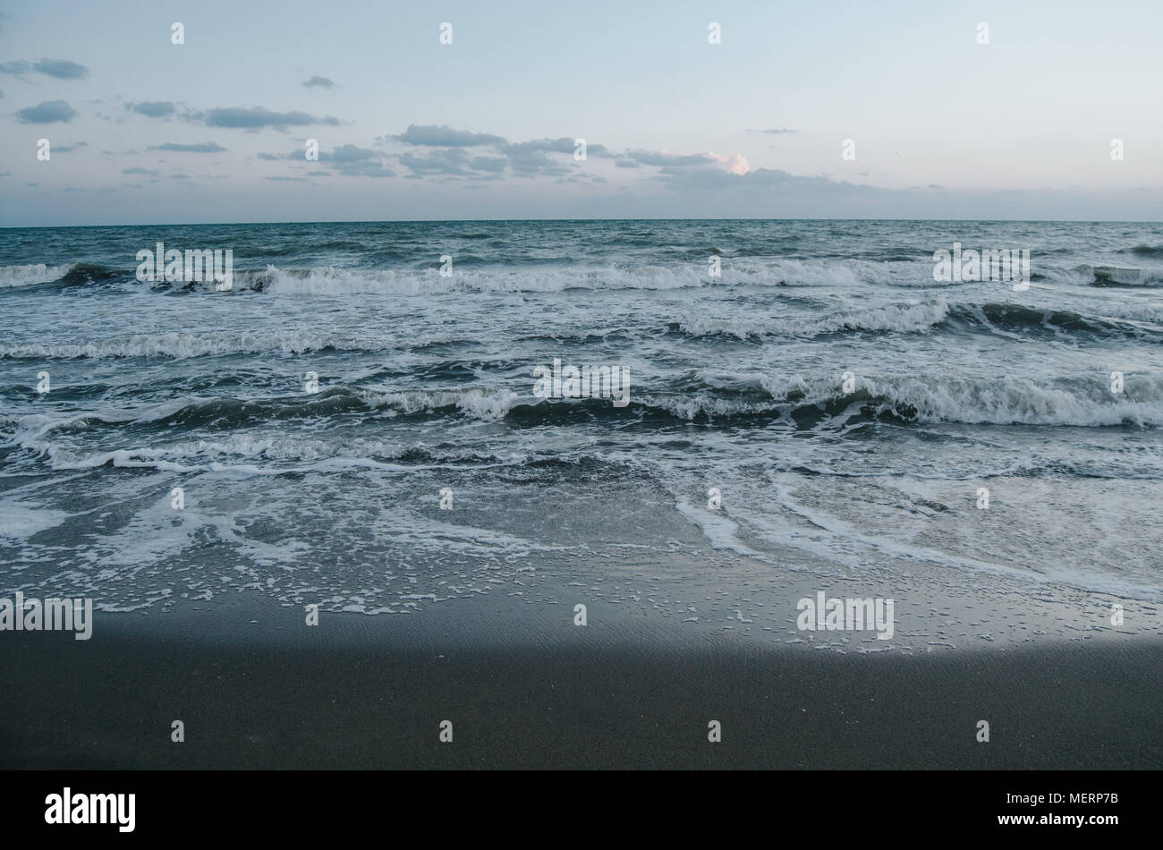 Beautiful wavy beach against sunset with blue sky Stock Photo - Alamy