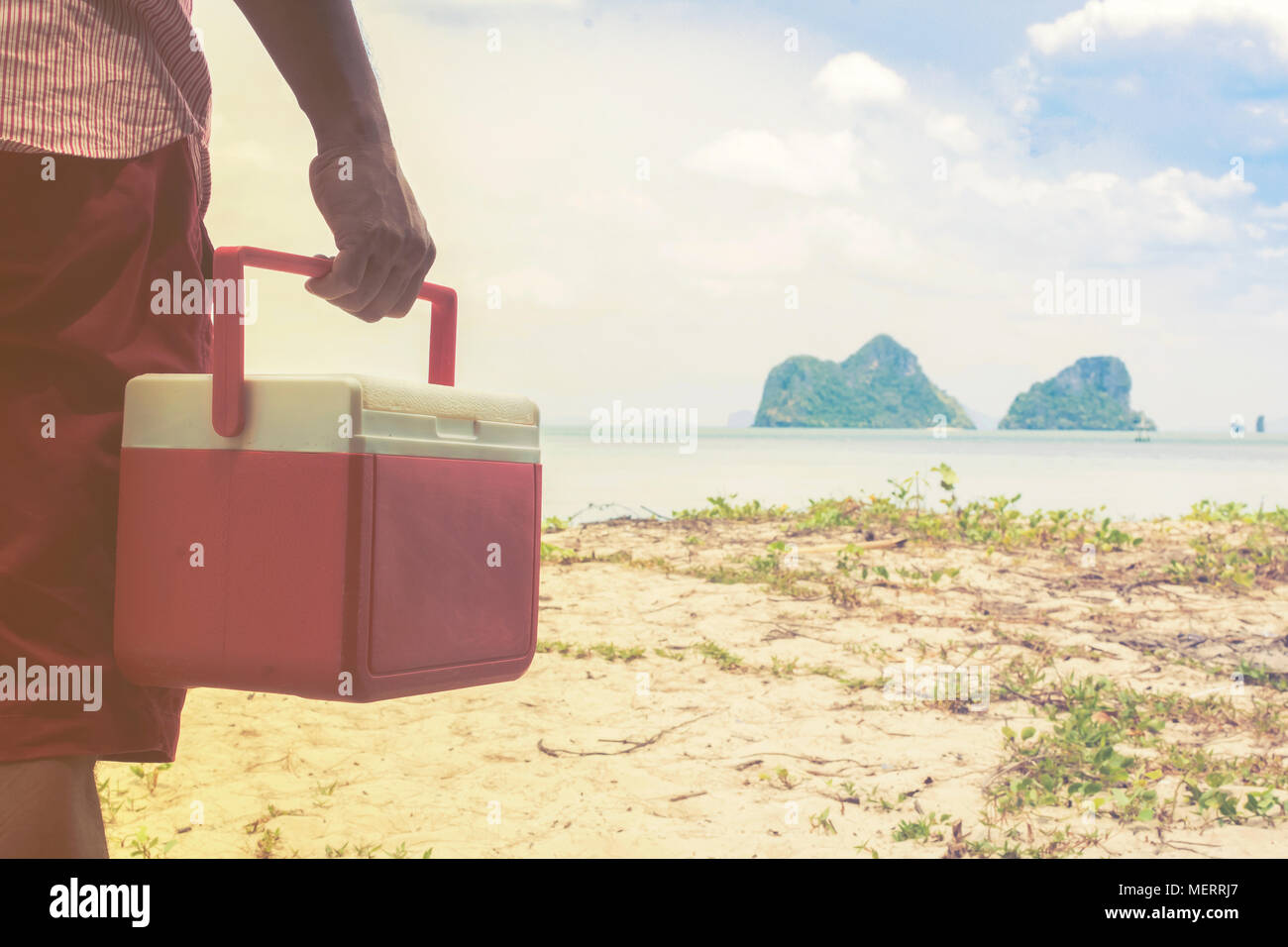 Hand of man red Ice box with background the beach and island view Stock ...