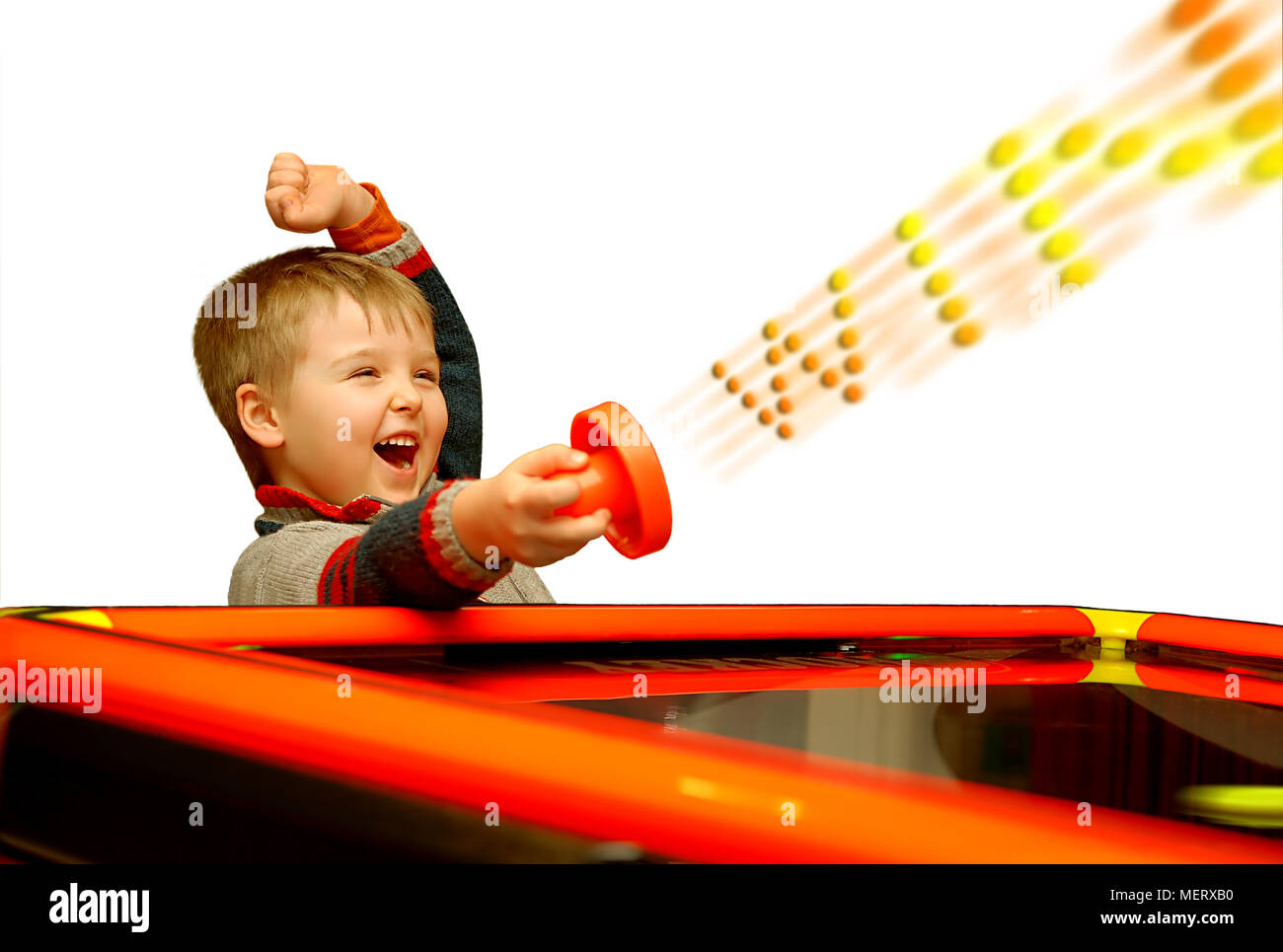 A child who has won his air hockey game, with a red mallet in his hand ...