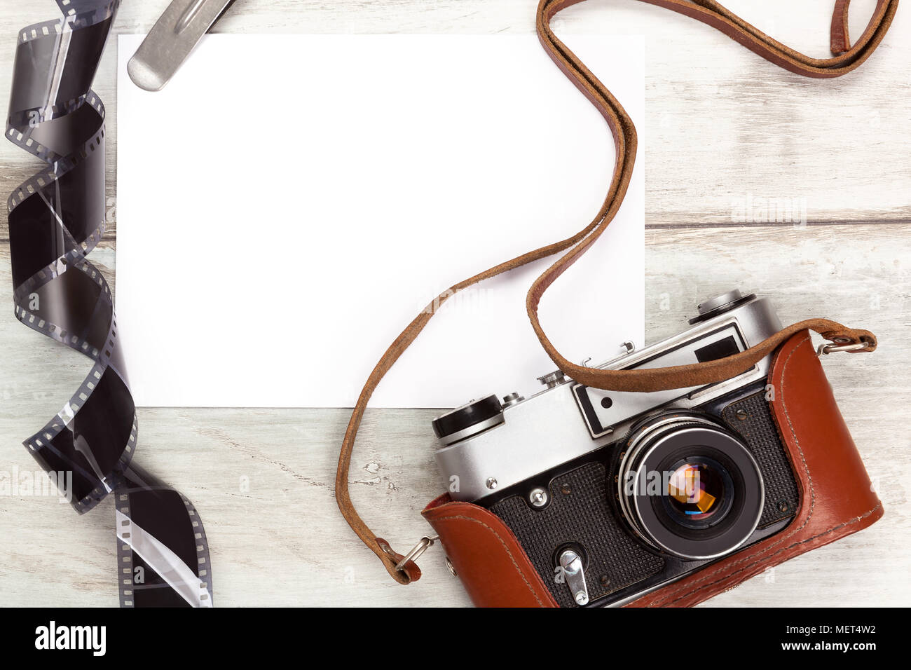 Retro camera with empty paper and negative film on wooden table from ...