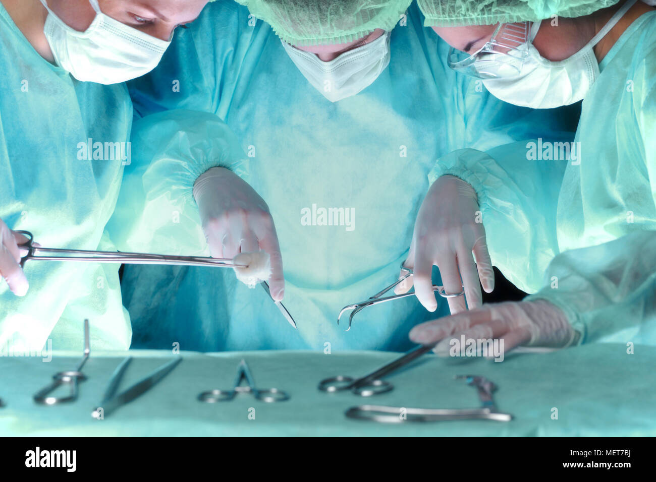Group of surgeons in masks performing operation. Scene of operation ...
