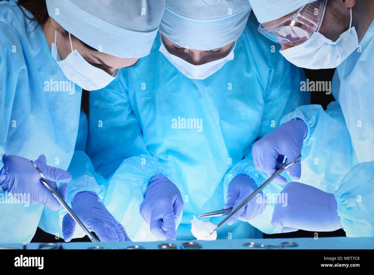 Group of surgeons at work while operating at hospital. Health care and ...
