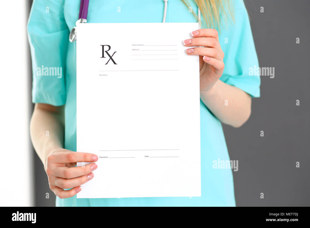Female doctor holds prescription form while standing straight in ...
