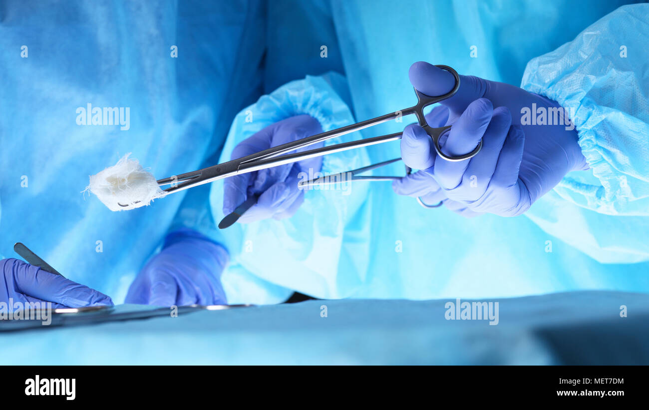 Surgeons hands holding surgical scissors and passing surgical equipment ...