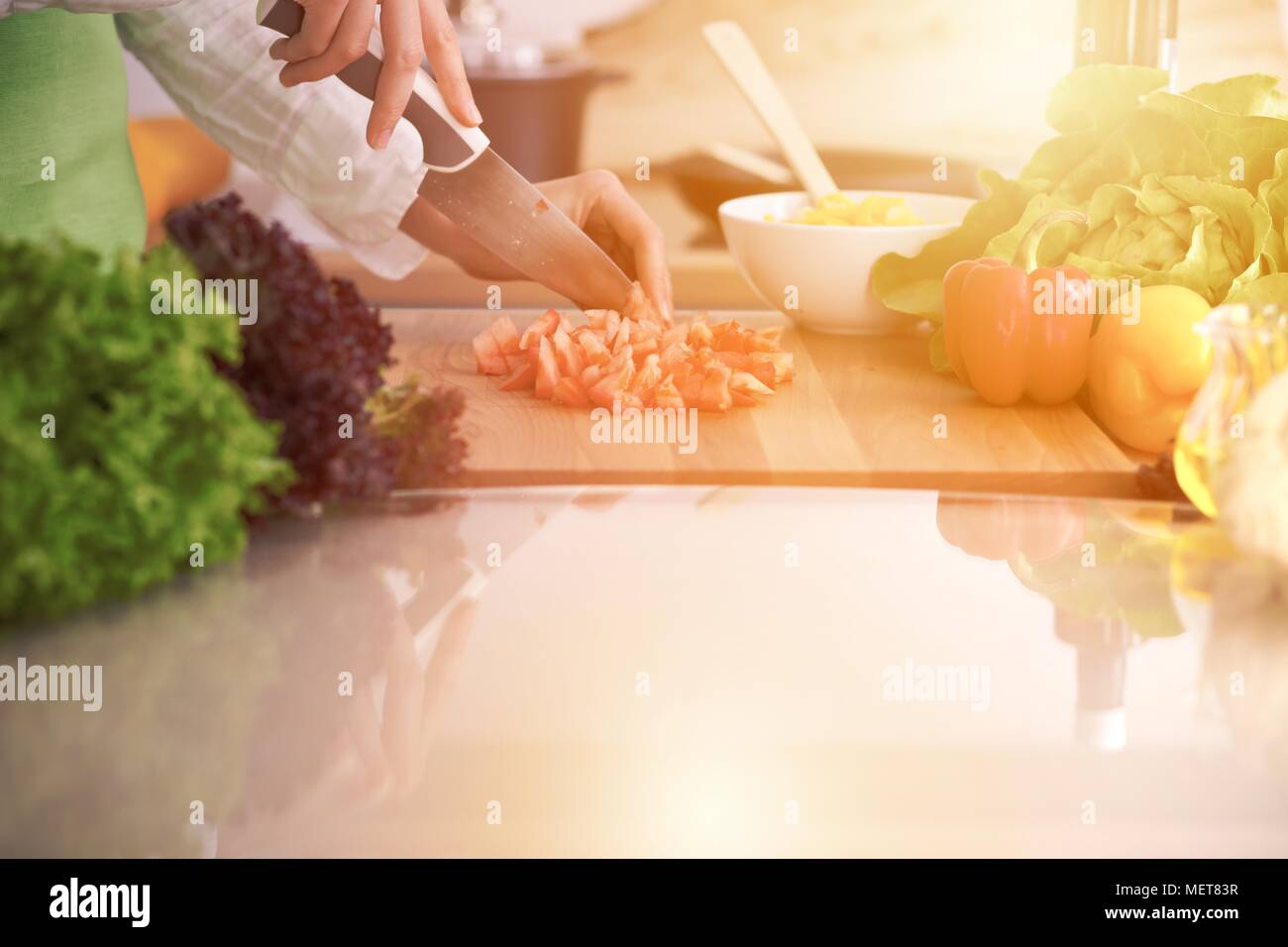 Close Up of human hands cooking vegetable salad in kitchen on the glass ...