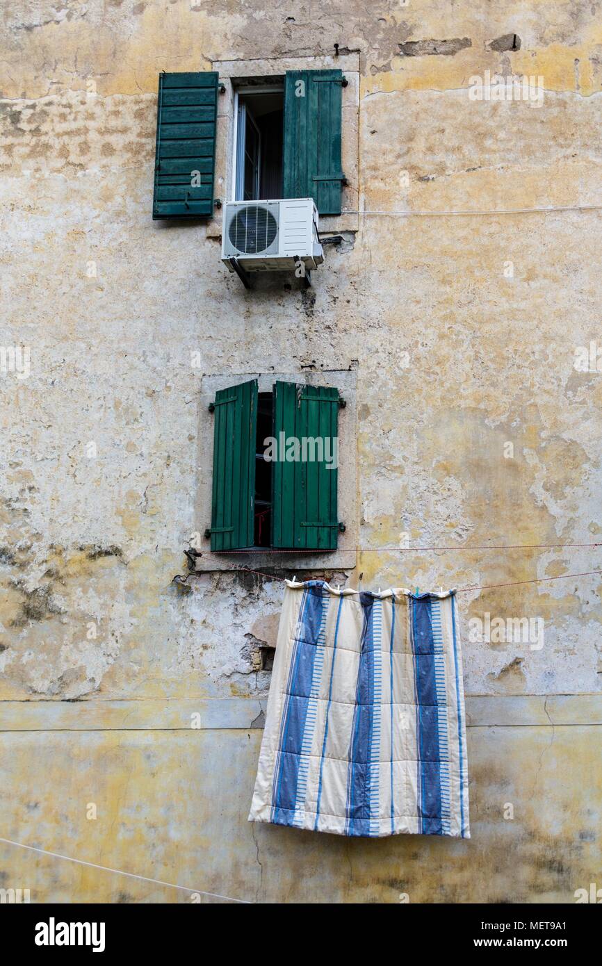 An Old Wall with Shutters, Air Conditioner and Laundry Stock Photo - Alamy