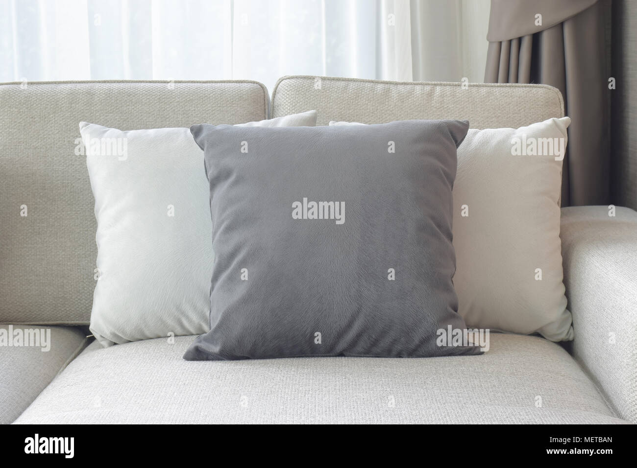 Gray and white pillows on beige sofa Stock Photo - Alamy