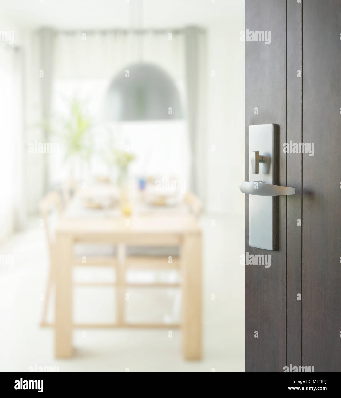 opened wooden door to dining table and comfortable chairs in modern ...