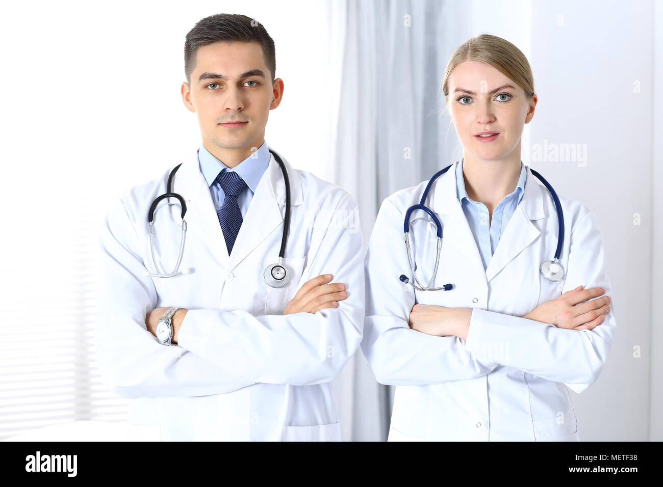 Doctors standing straight with arms crossed in hospital. Physicians ...