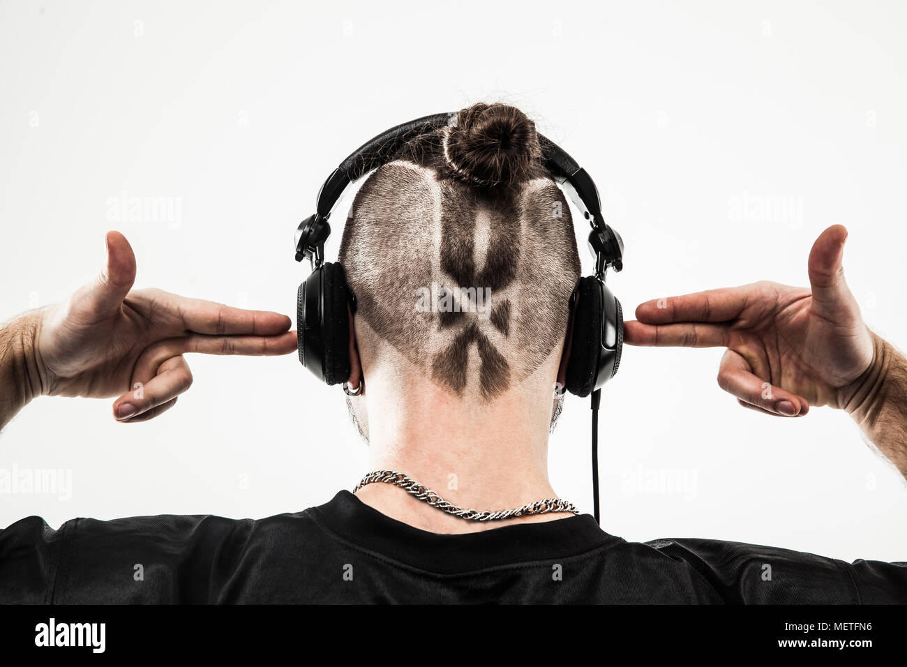 rear view - the rapper headphones with a stylish hairdo and a tattoo ...