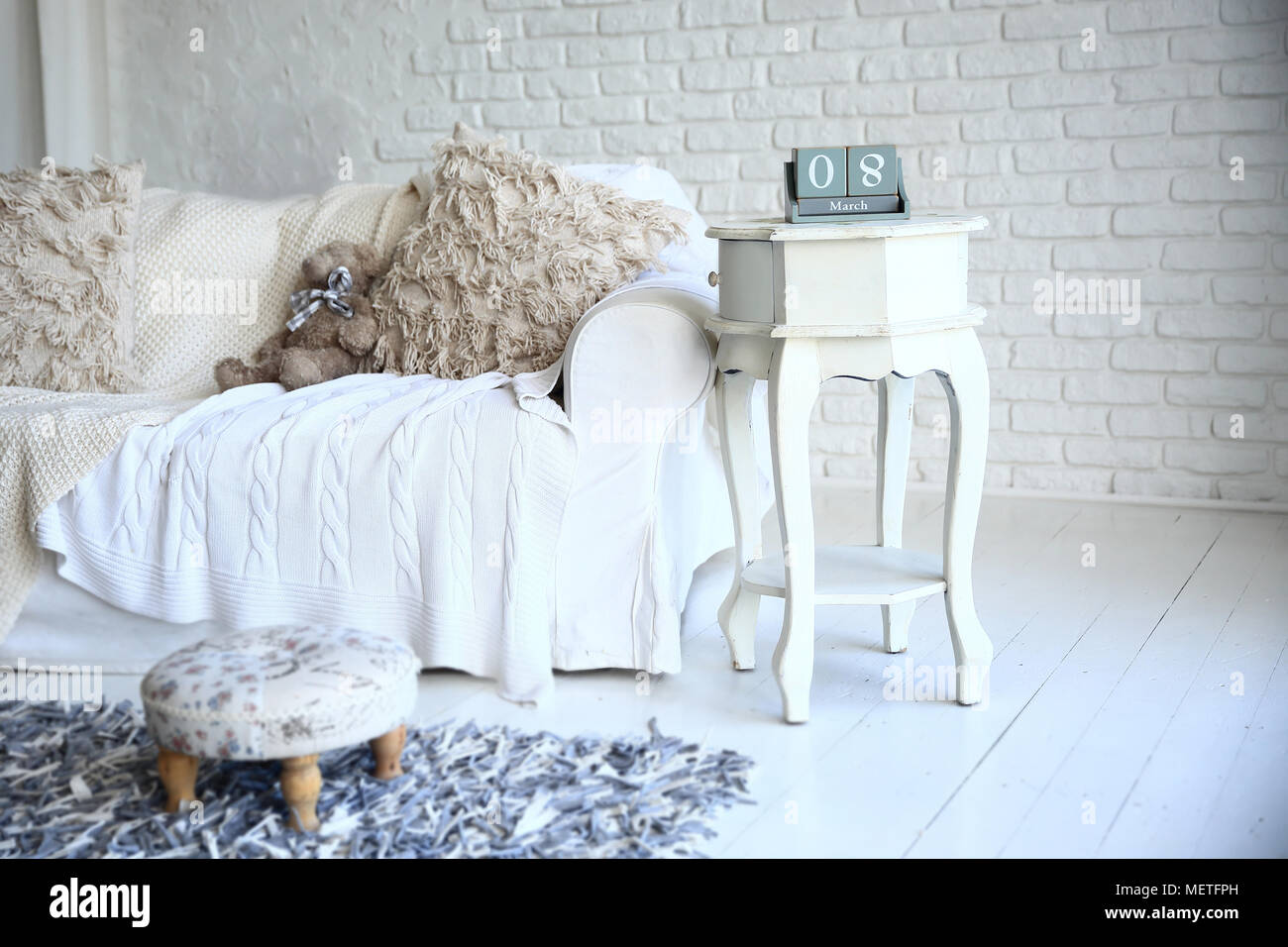 white sofa and nightstand with changeover calendar in a stylish living ...